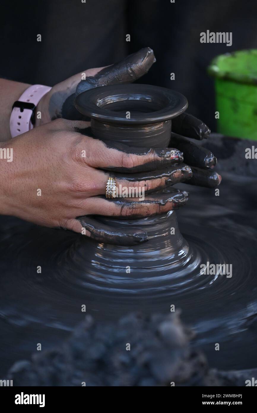 Closeup of two hands modeling clay during a pottery workshop in Pottery ...