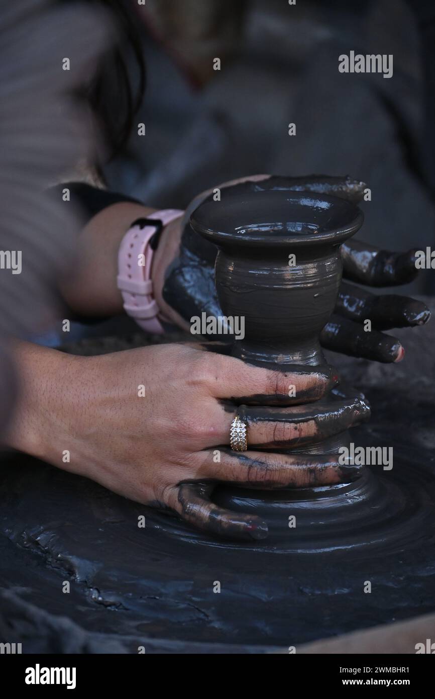 Closeup of two hands modeling clay during a pottery workshop in Pottery ...