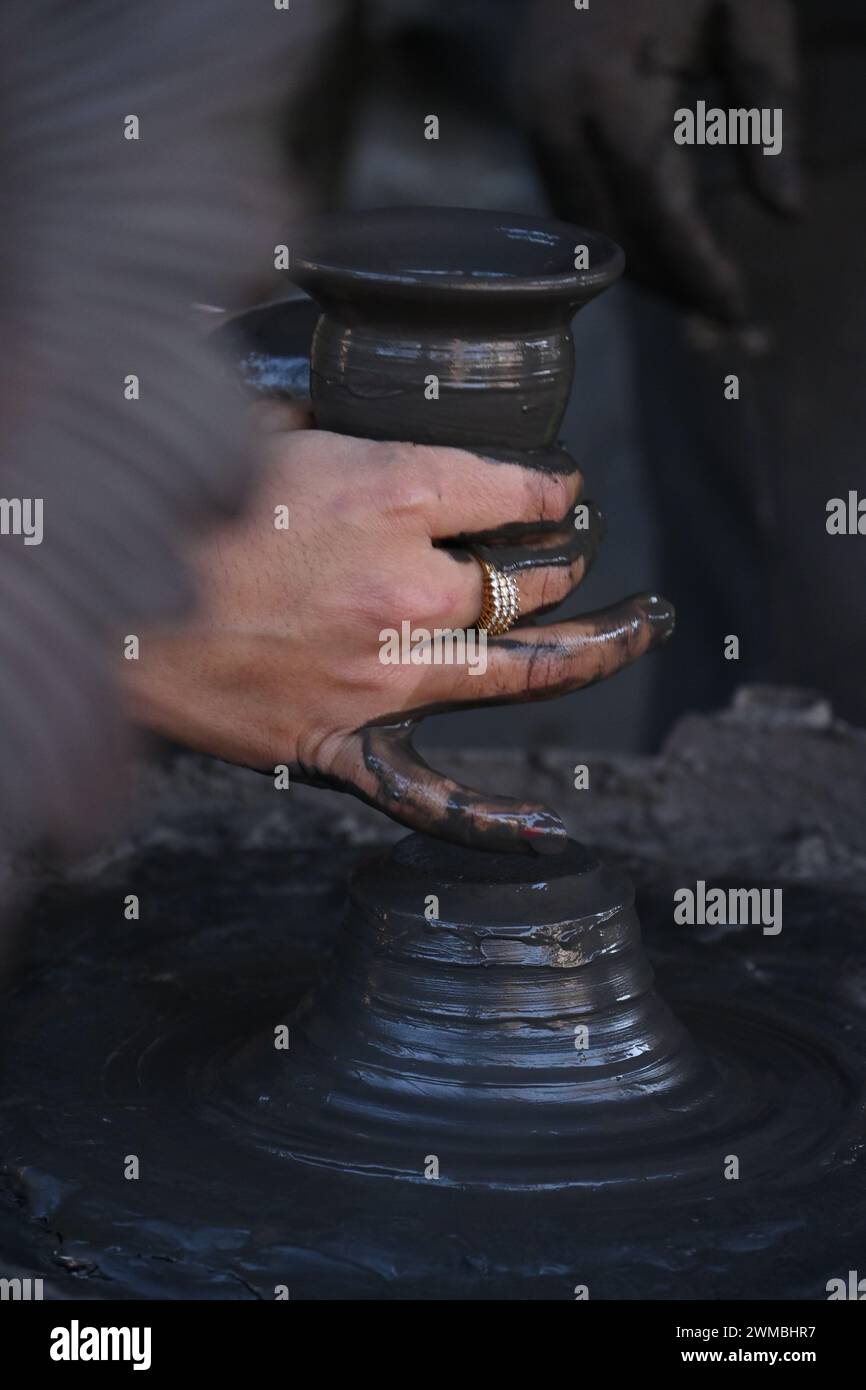 Closeup of two hands modeling clay during a pottery workshop in Pottery ...