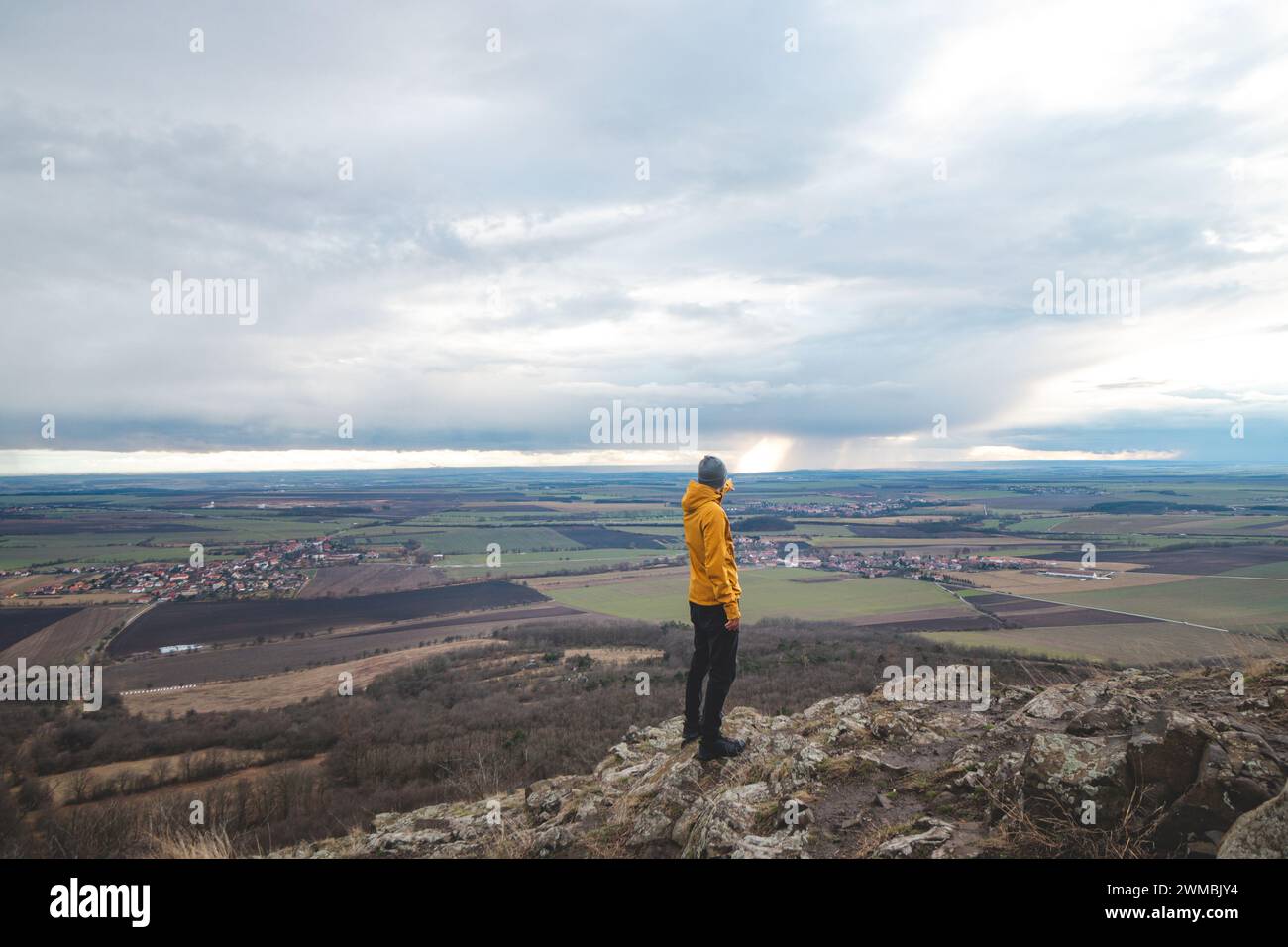 Traveller in a yellow jacket stands on top of Mount Rip and is pointing ...