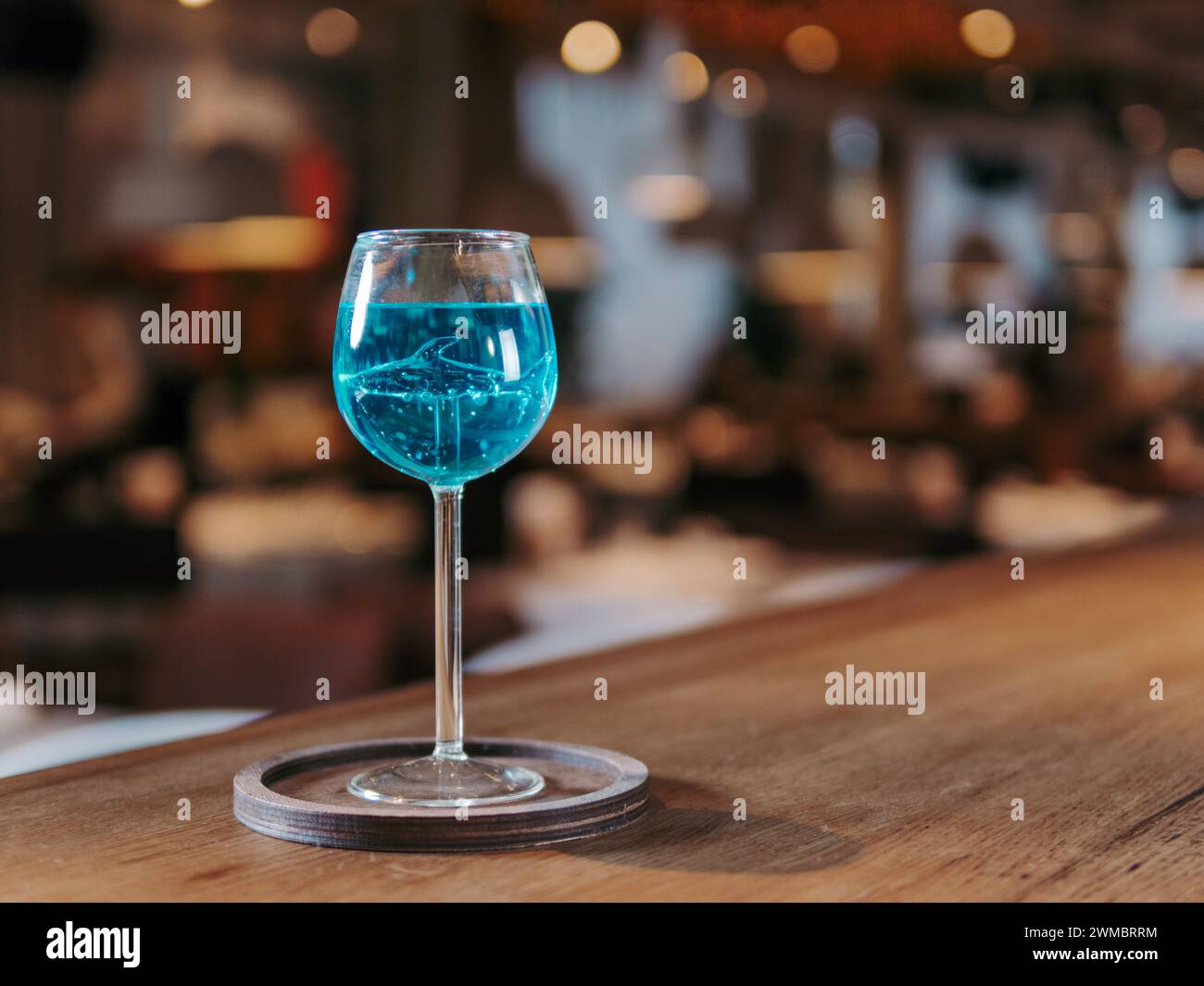 Glass of blue lagoon cocktail in shark high stem cocktail glass on ...