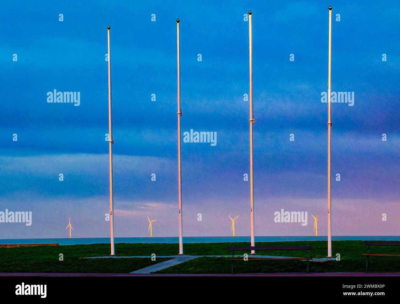 Flag poles in front of wind power generators in the North Sea off ...