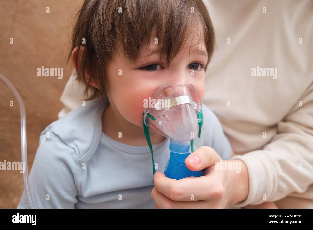 Inhalation for a sick asthmatic child to treat allergies. A mother ...