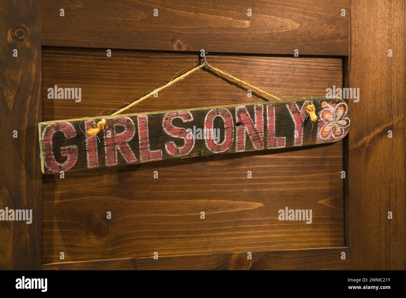 Red painted girls only notice sign on brown stained wooden bedroom door ...