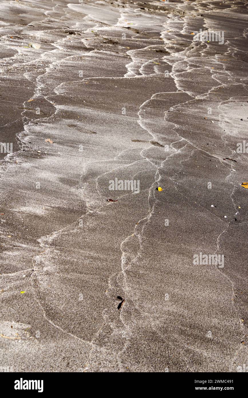 Intricate patterns left in the black volcanic sand by the tide ...