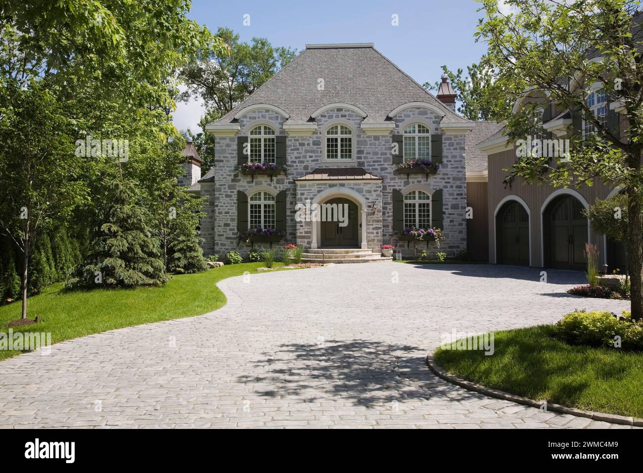 French Manor style natural stone home with three car garage and paving ...