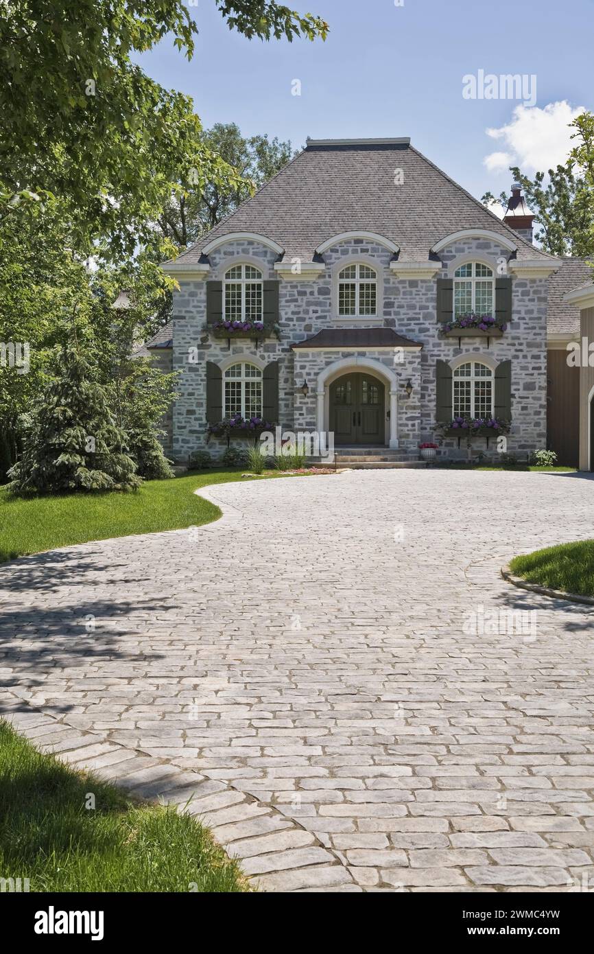 French Manor style natural stone home with paving stone driveway Stock ...