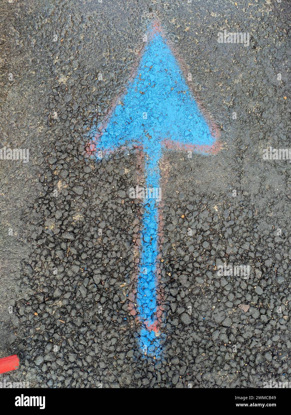 A Blue Arrow Painted on Pavement Pointing Stock Photo - Alamy