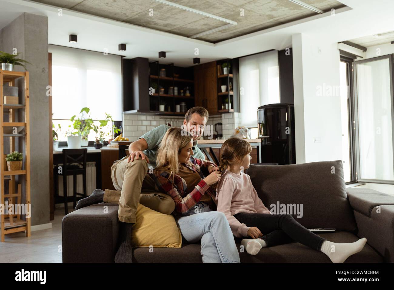 Family enjoys a relaxed moment together on the sofa, with playful ...