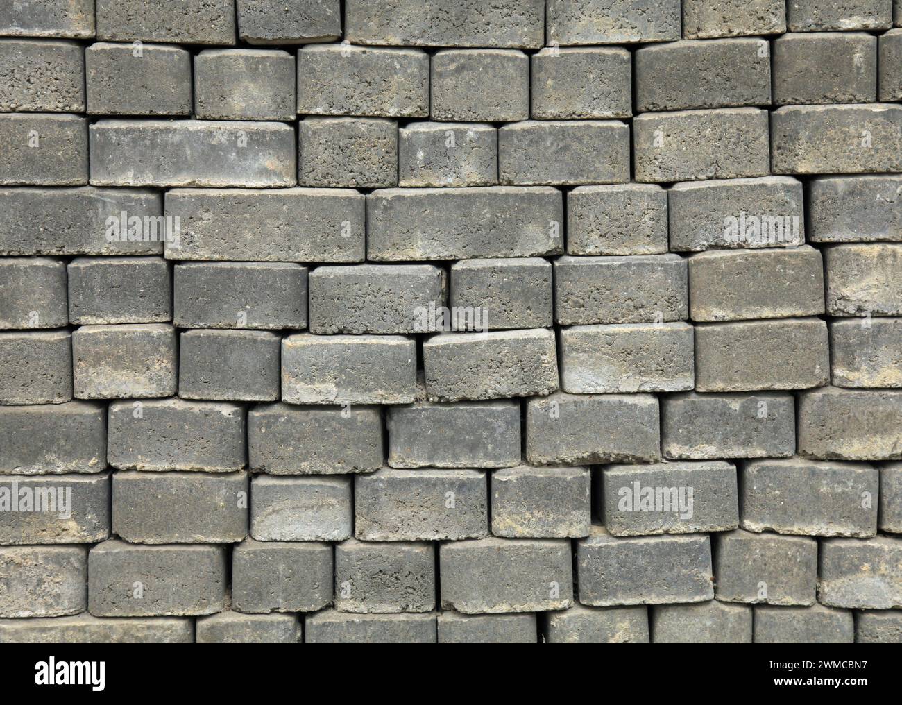 The surface of a wall or fence lined with gray bricks. Paving slabs of ...