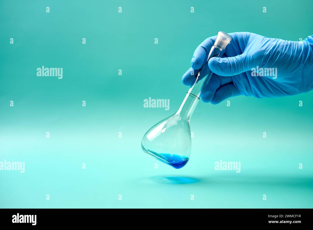 Hand of unrecognizable researcher in latex glove holding titration ...