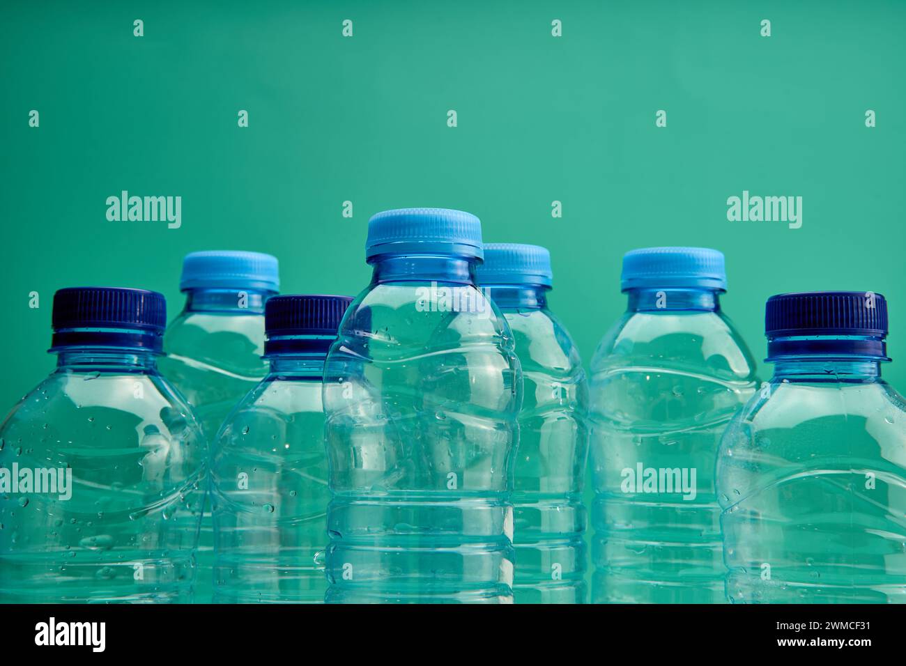Closeup of transparent disposable plastic bottles with blue covers ...