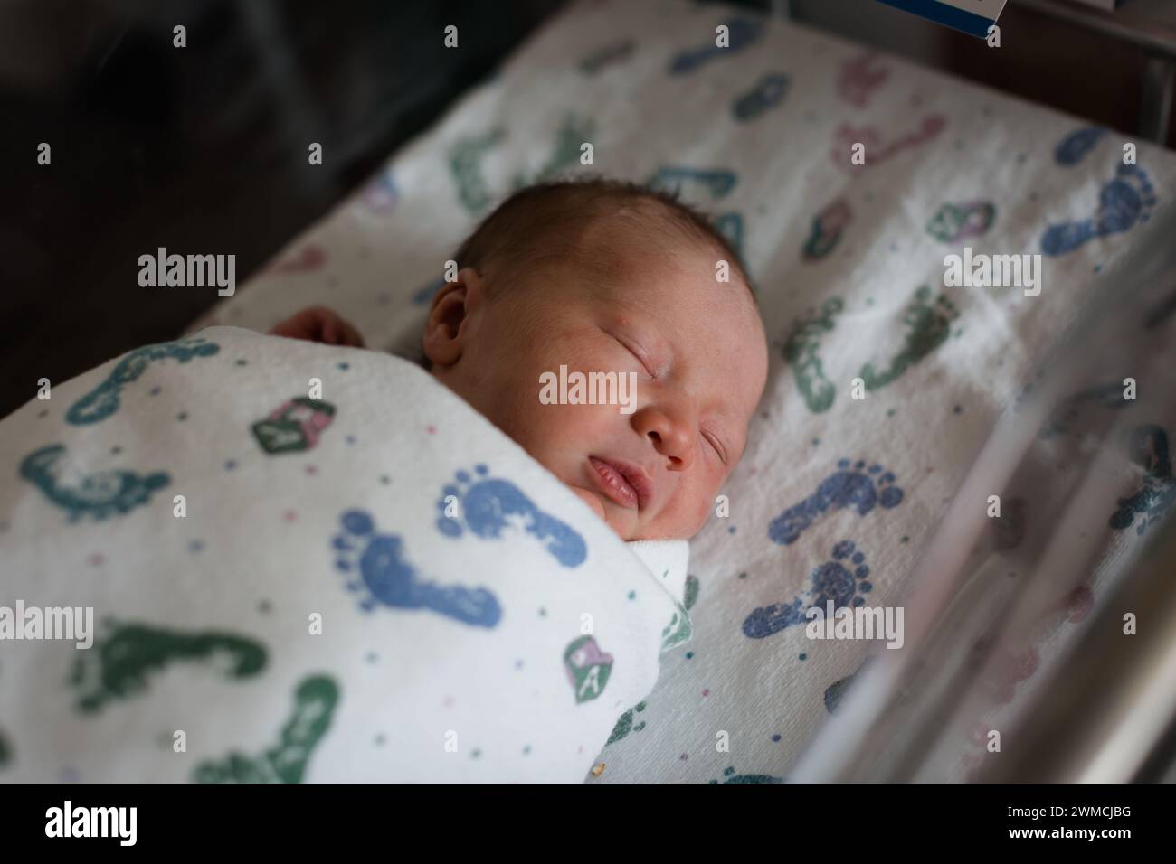 Close-up of a newborn baby swaddled in a blanket sleeping Stock Photo ...