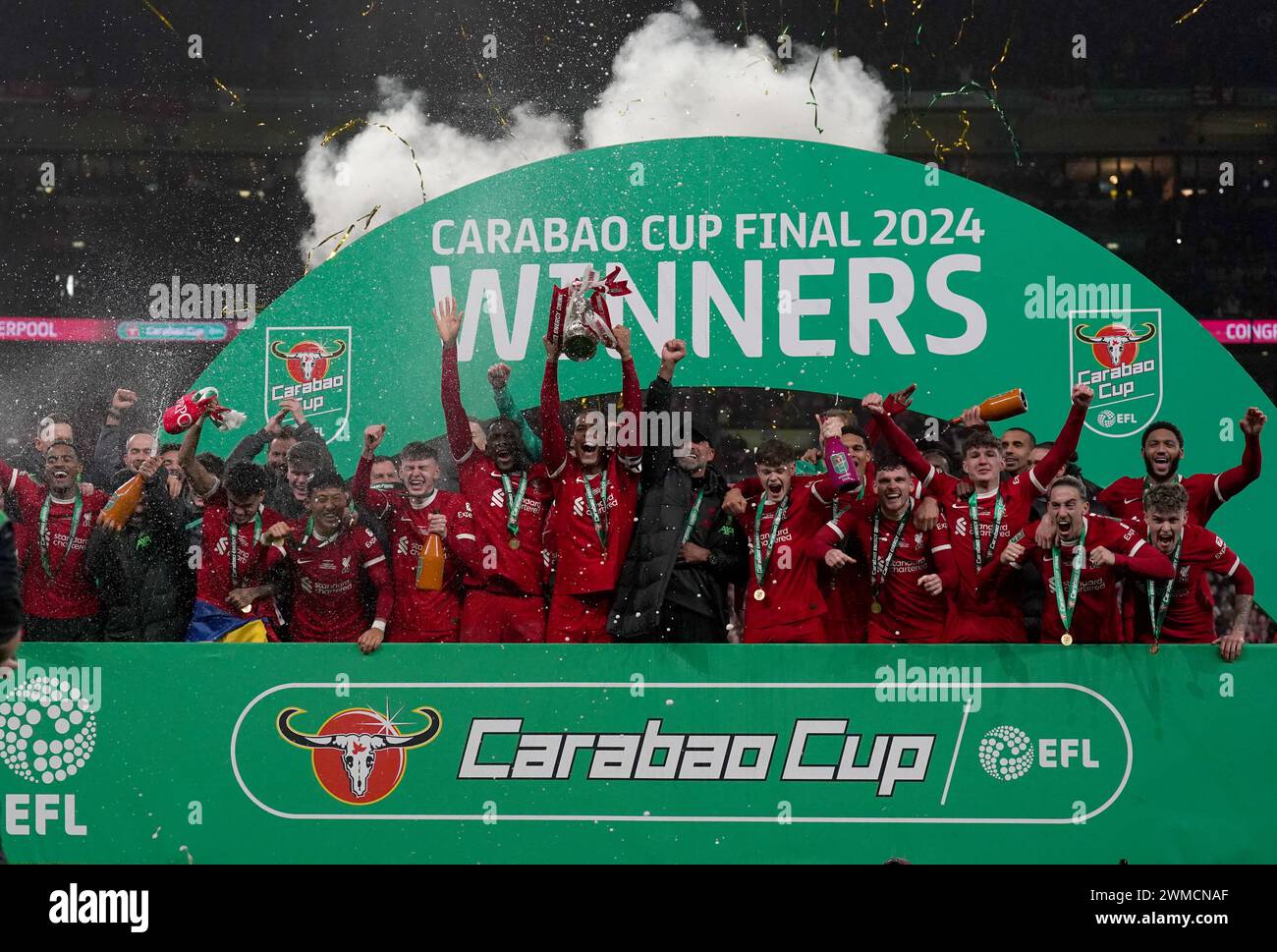 Liverpool players celebrate on the pitch with the trophy after winning ...