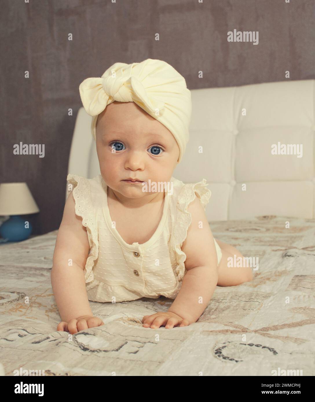 serious little child trying to crawl on the bed Stock Photo - Alamy
