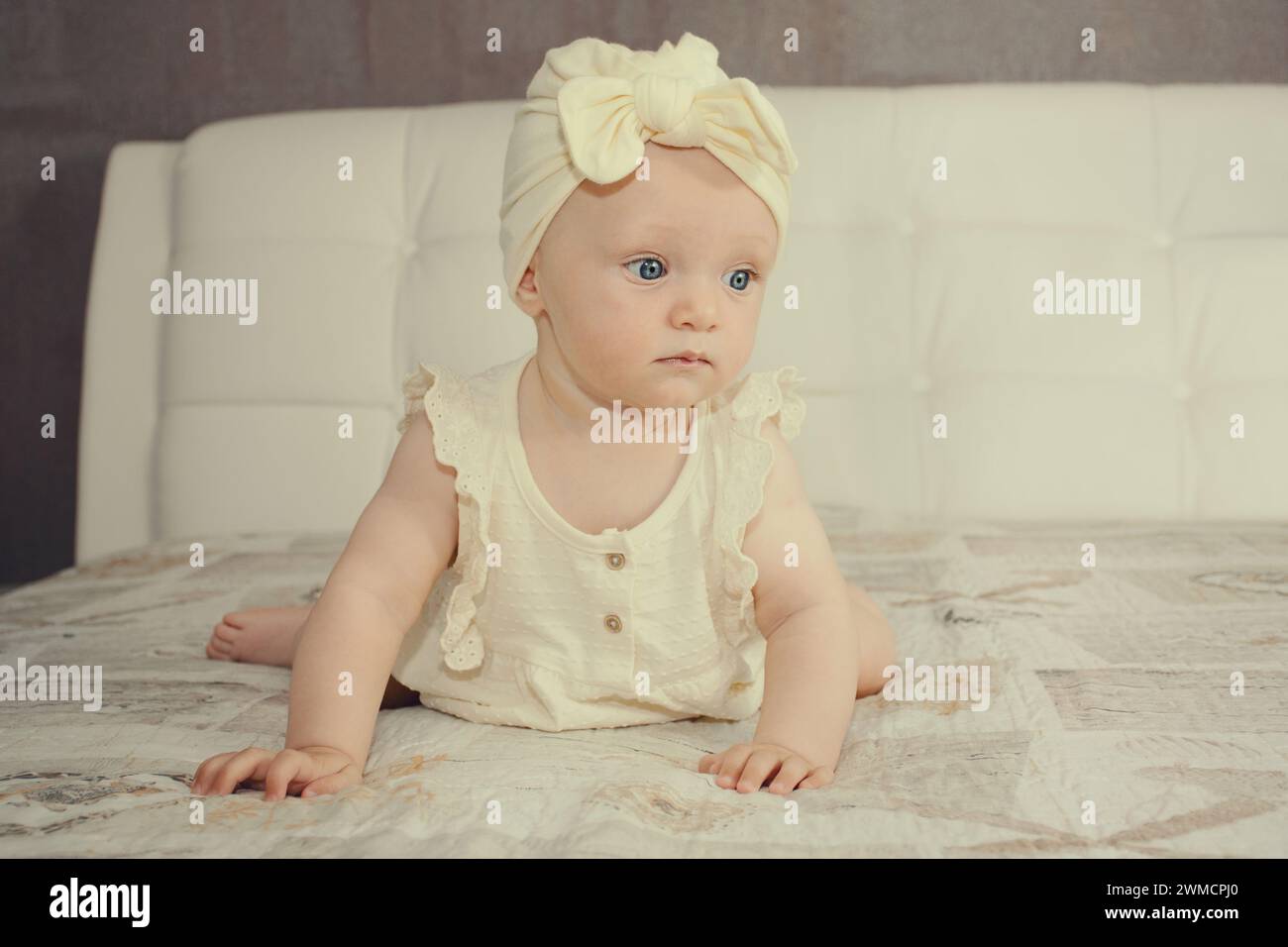 serious little child trying to crawl on the bed Stock Photo - Alamy
