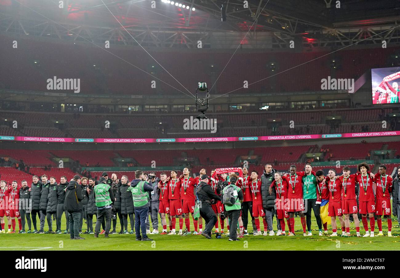 Liverpool's players and staff stand in front of their fans as they sign ...