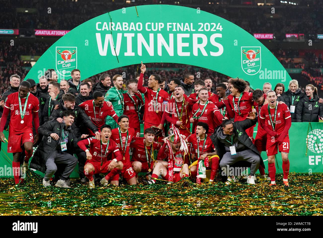 Liverpool players celebrate on the pitch with the trophy after winning ...