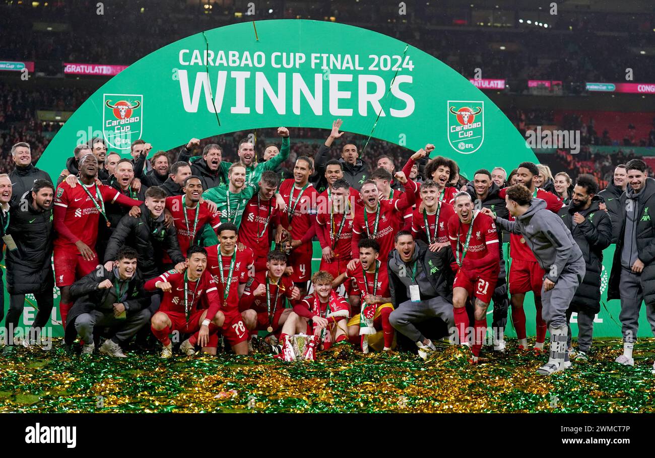Liverpool players celebrate on the pitch with the trophy after winning ...