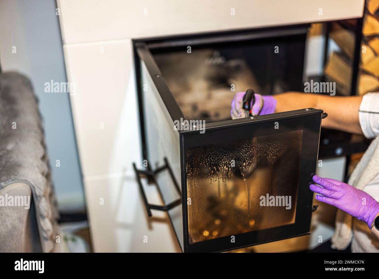 Close-up view of woman's hand cleaning soot from glass door of ...