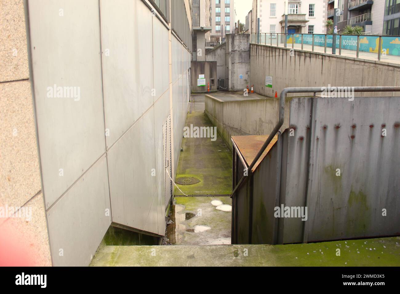 A photo of a small staircase leading down to a concrete alleyway Stock ...