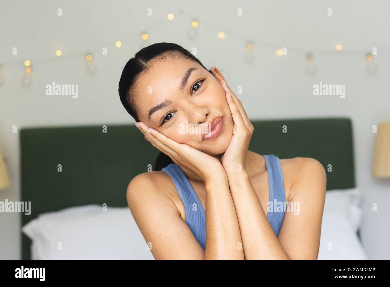 Young Caucasian woman poses playfully in a bedroom setting Stock Photo ...
