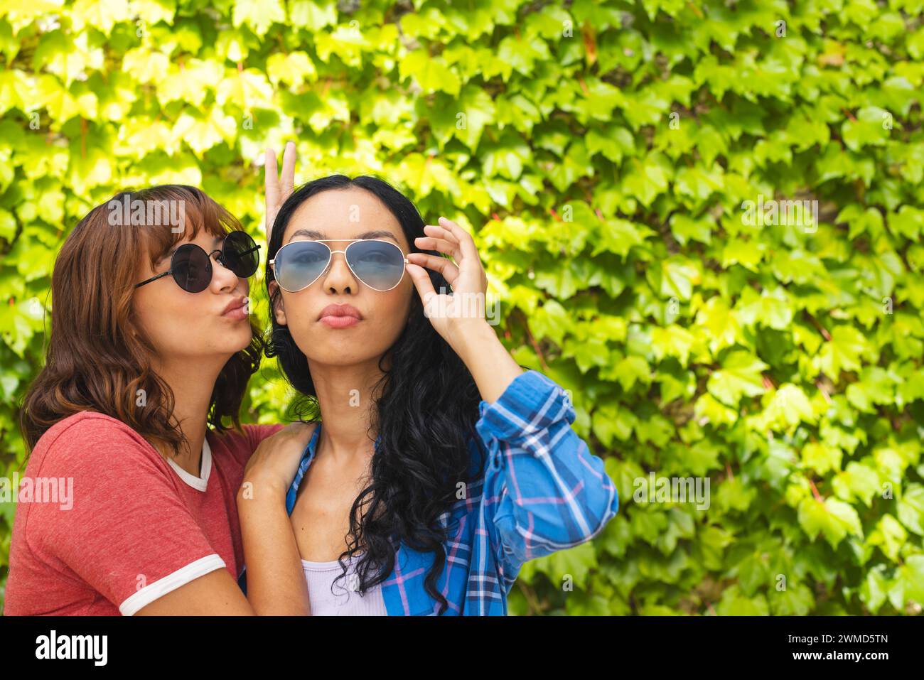 Two Young Biracial Women Pose Playfully Outdoors With Copy Space Stock