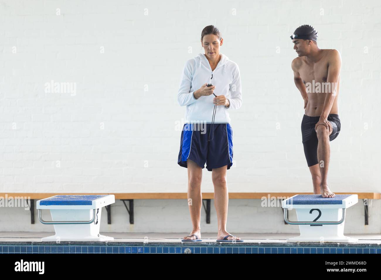 Caucasian woman and young biracial male athlete swimmer stand by the ...