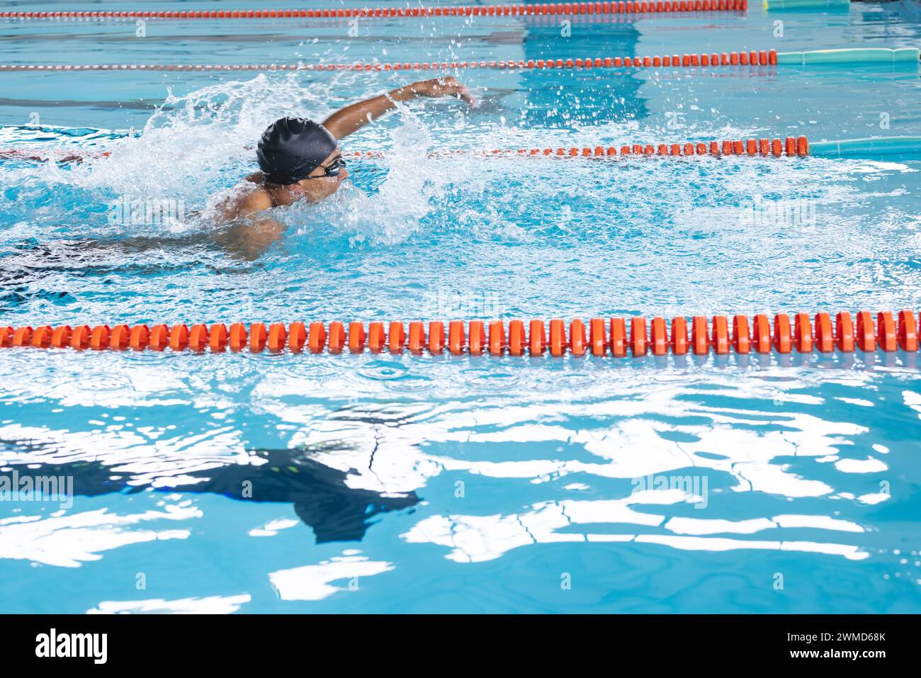 Athlete swims vigorously in a pool, with copy space. The image captures ...