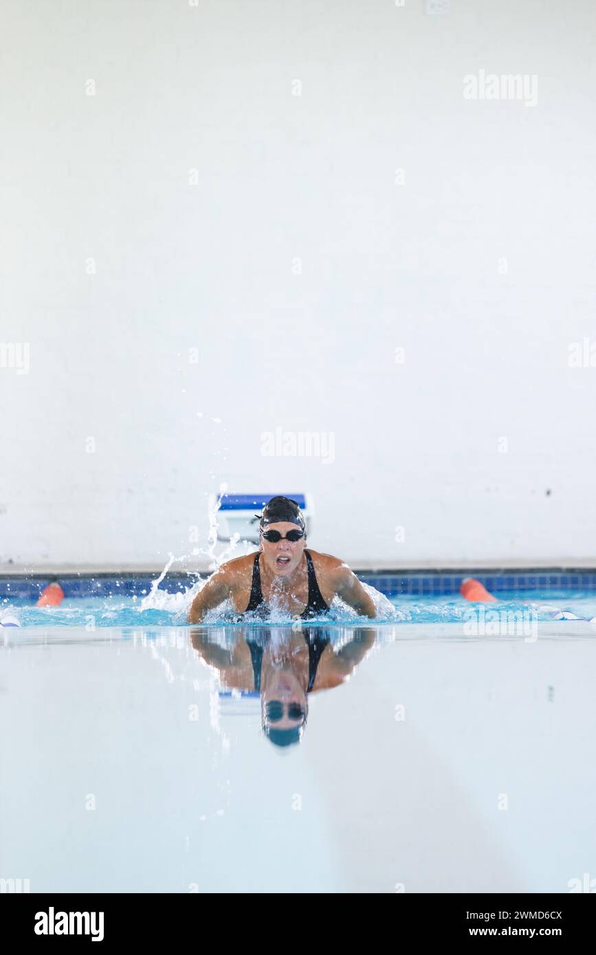 Caucasian female athlete swimmer swims in an indoor pool Stock Photo ...