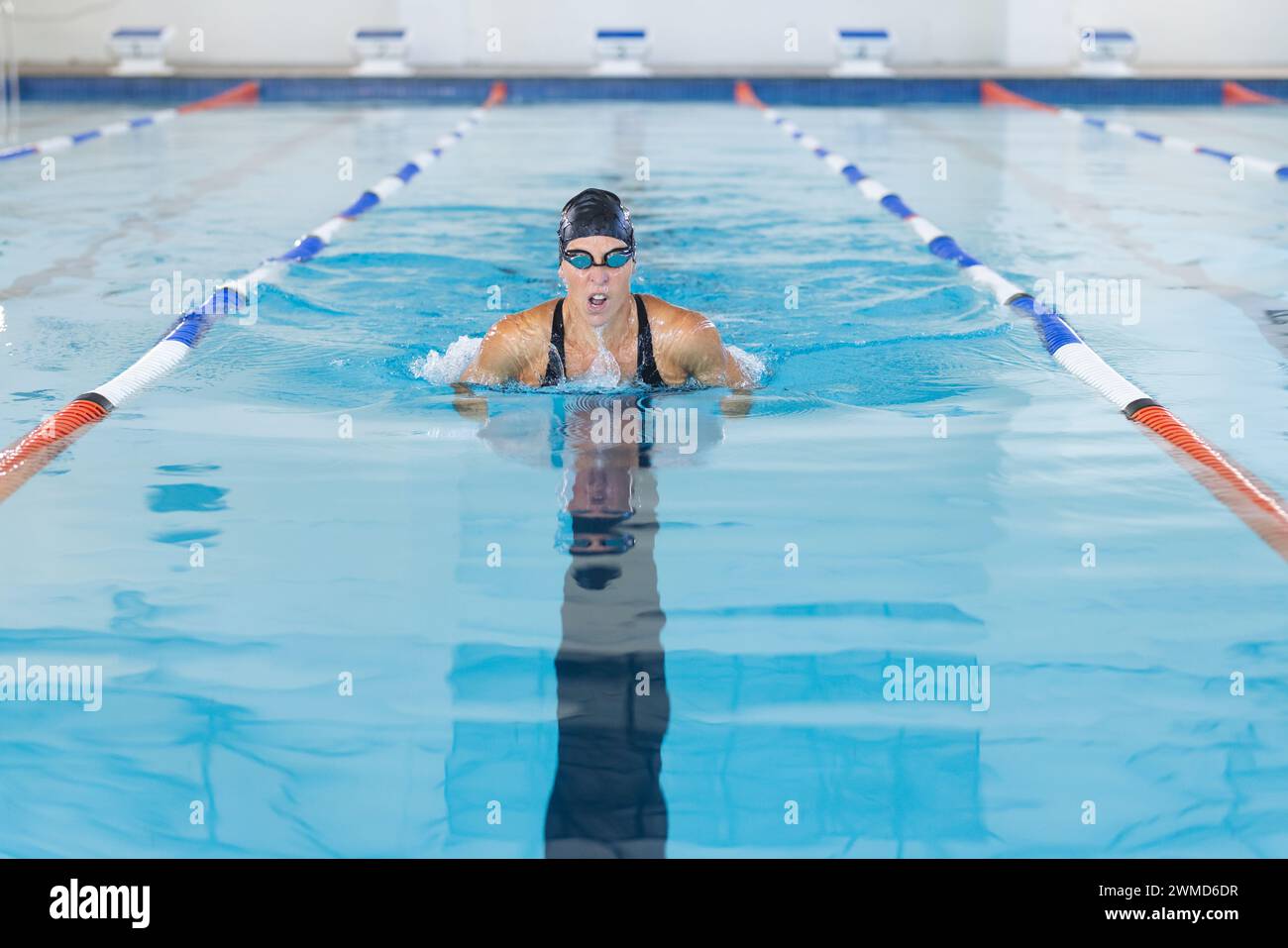 Caucasian female athlete swimmer swims in an indoor pool Stock Photo ...