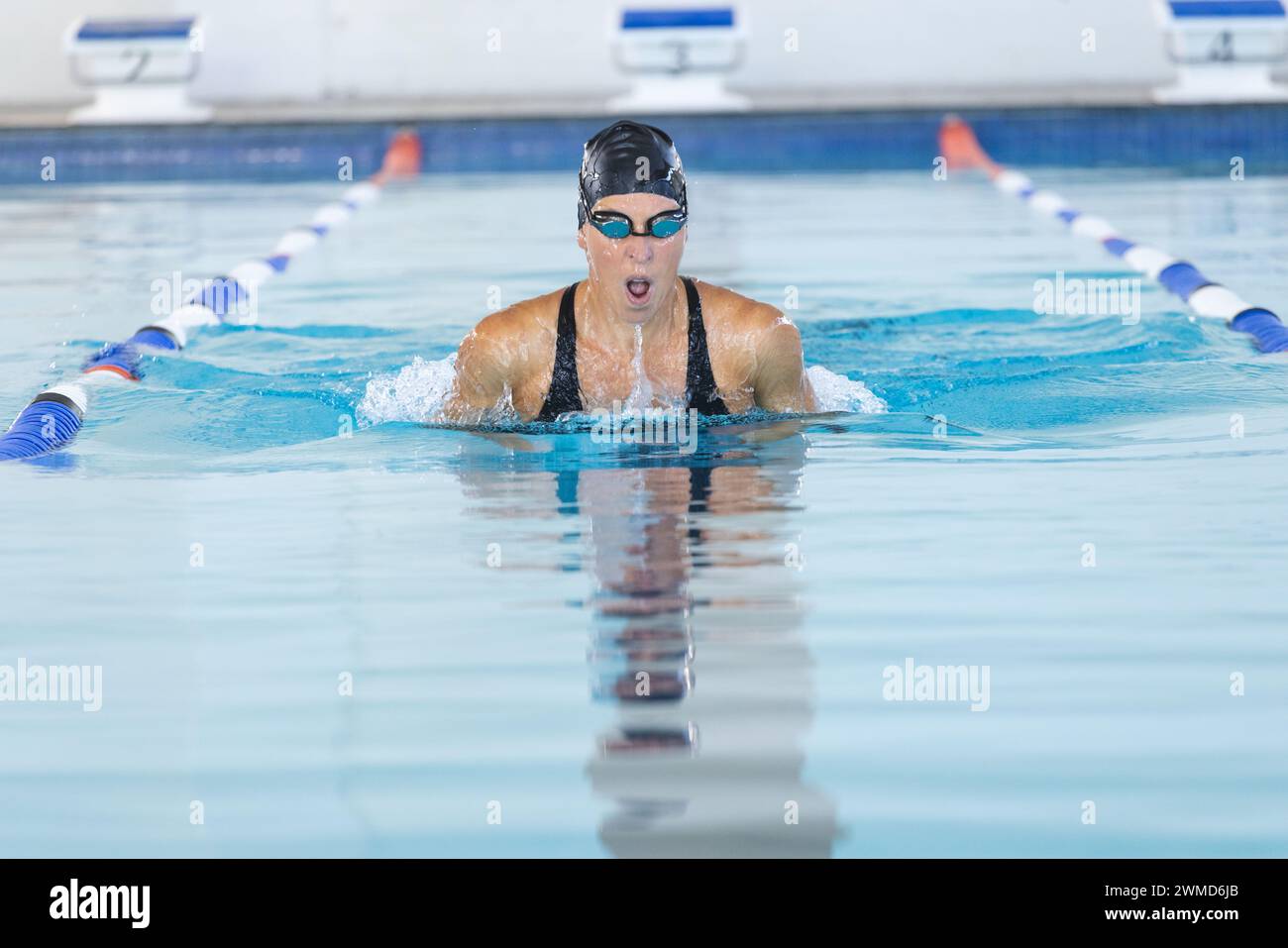 Caucasian female athlete swimmer swims in an indoor pool Stock Photo ...