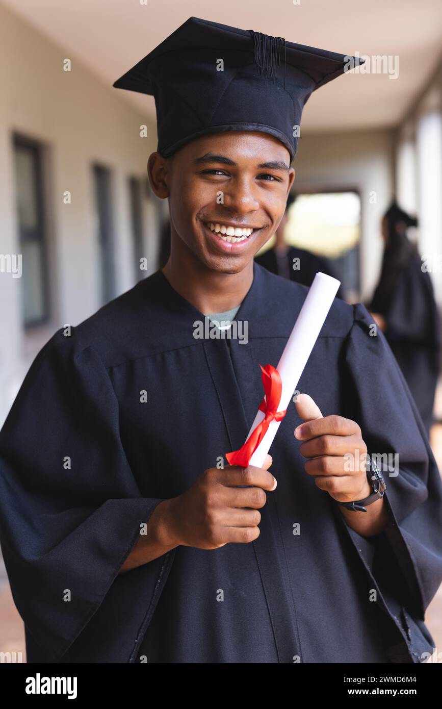 Graduating biracial teenage boy smiling proudly. His achievement marks ...