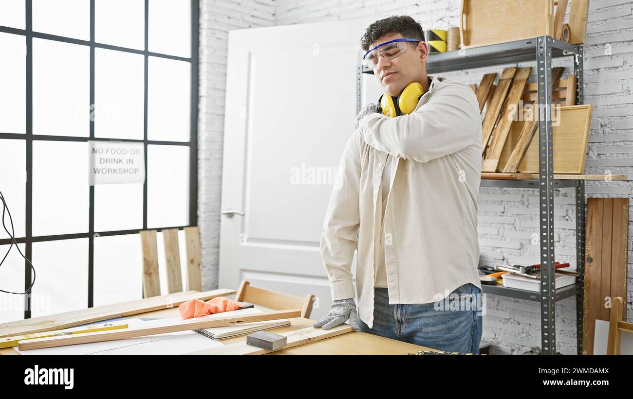 A young man with a beard experiences shoulder pain in a well-organized ...