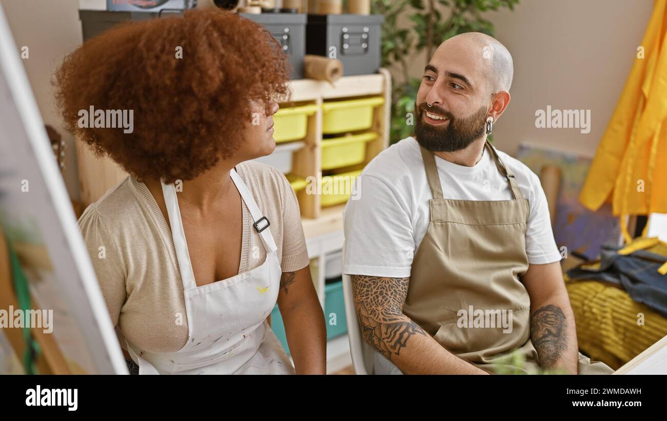 At the art studio, two smiling artists, partners in creativity, sitting ...