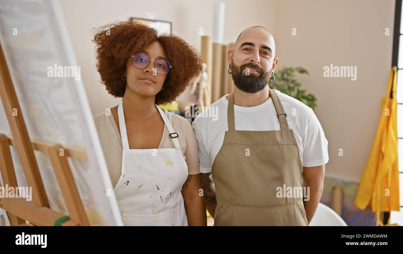 Two artists, partners in art, standing together, arms crossed, serious ...