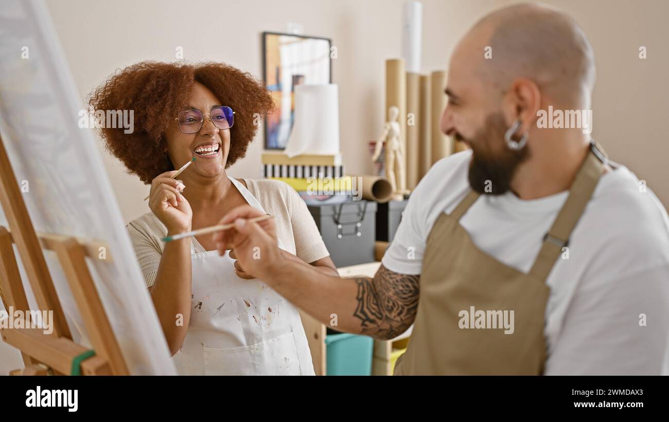 Smiling and confident, two artists stand together, paintbrushes dancing ...