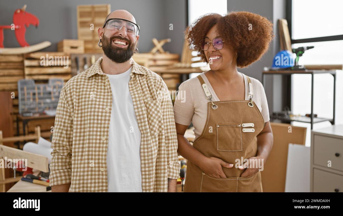 Two smiling carpenters, clad in safety glasses, standing united at ...