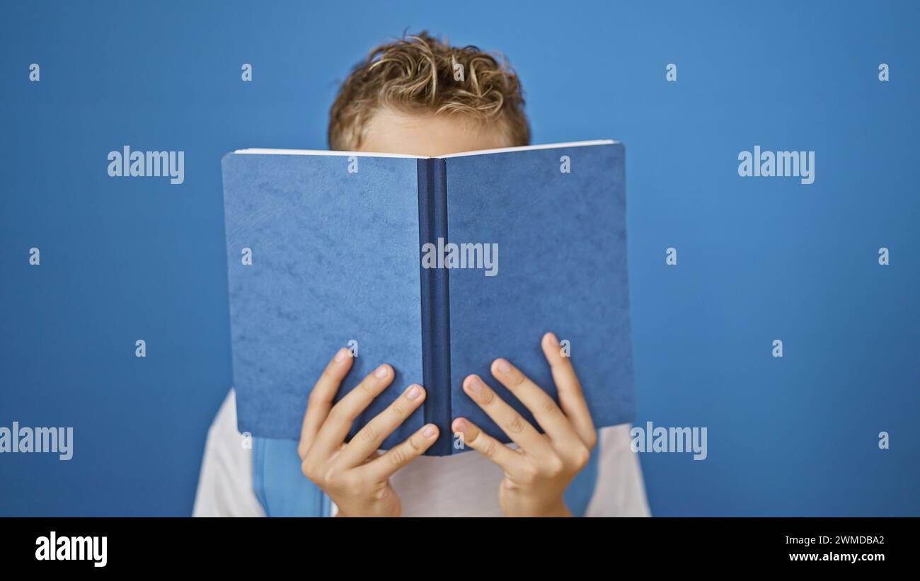 Adorable blond boy student, an eager learner, engrossed in academic ...