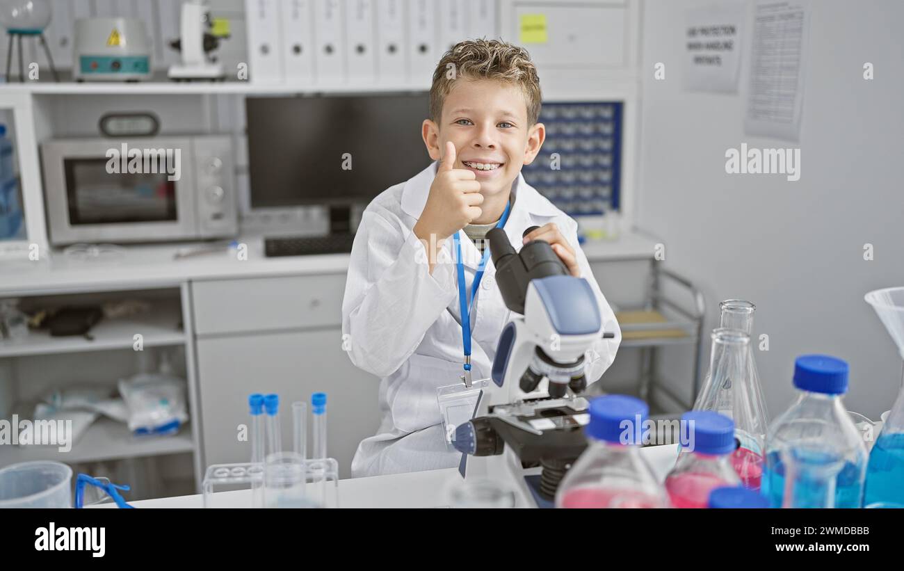 Adorable little blond boy, a budding scientist, giving a thumb up ...