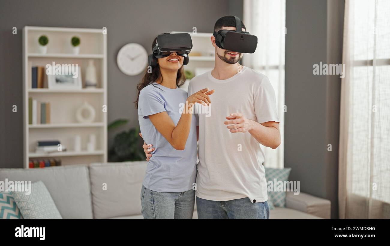 Gorgeous couple sharing love, gaming together with vr glasses at home ...