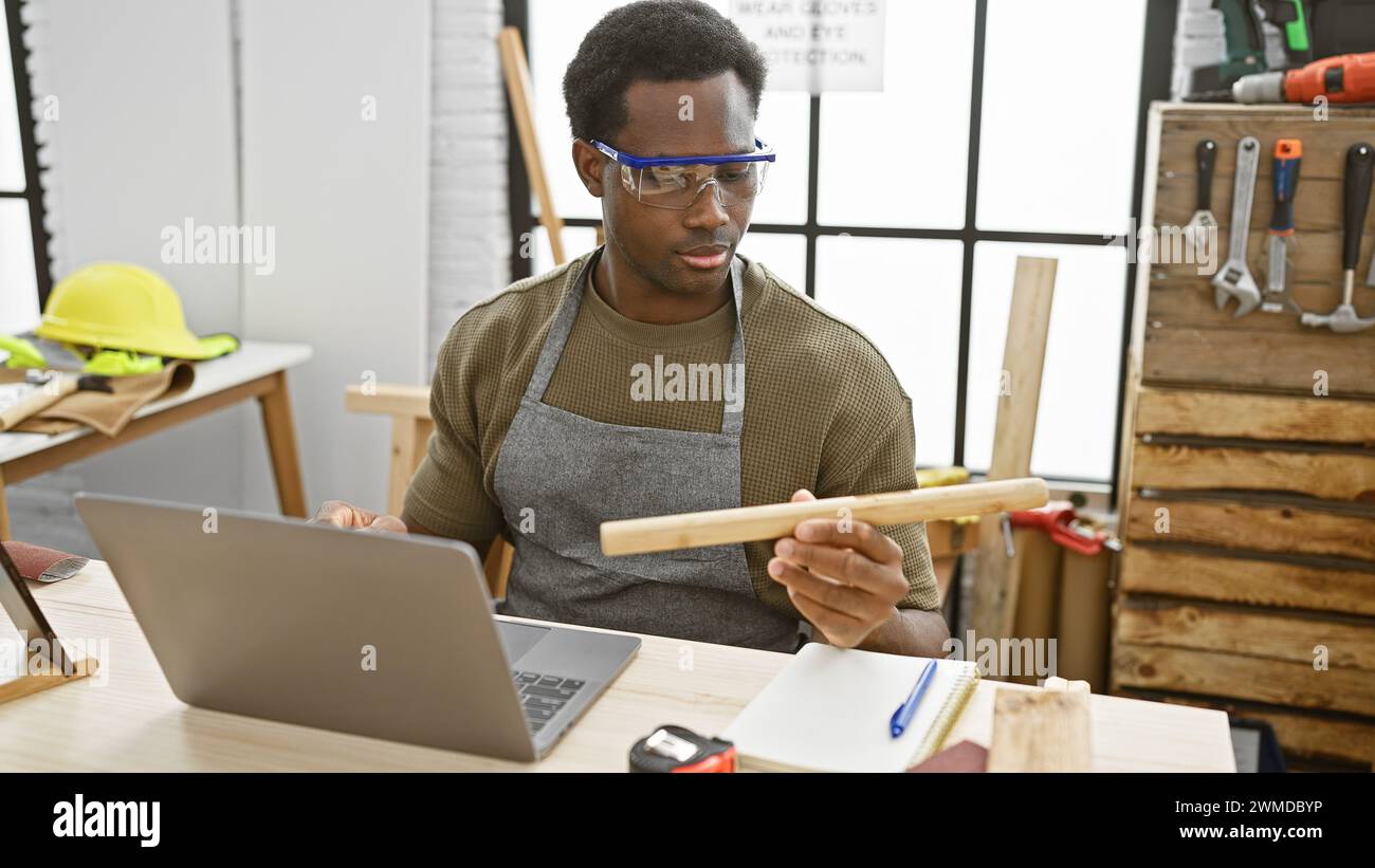 African american man examining a piece of wood in a well-equipped ...