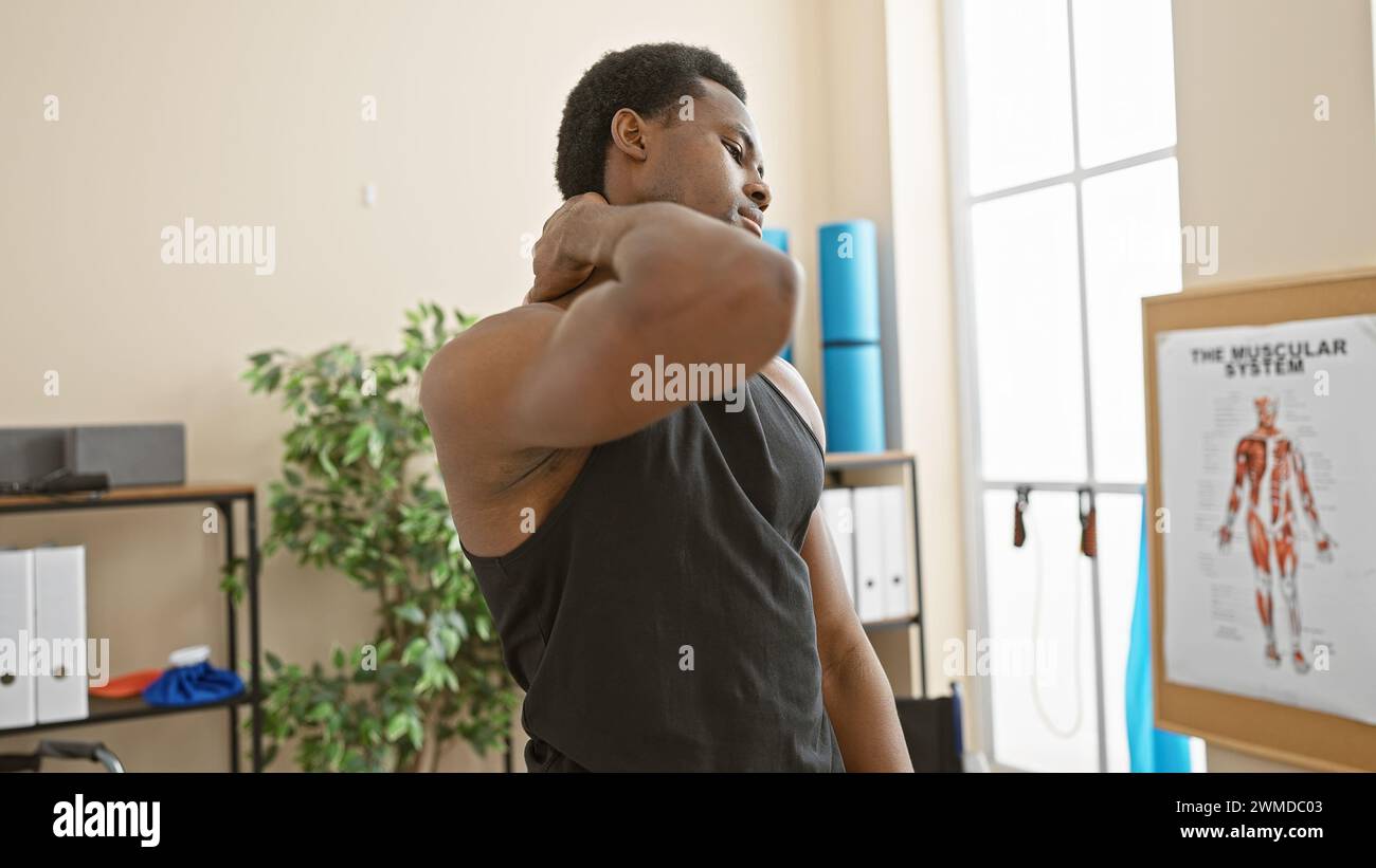 An african american man experiencing neck pain indoors in a rehab ...