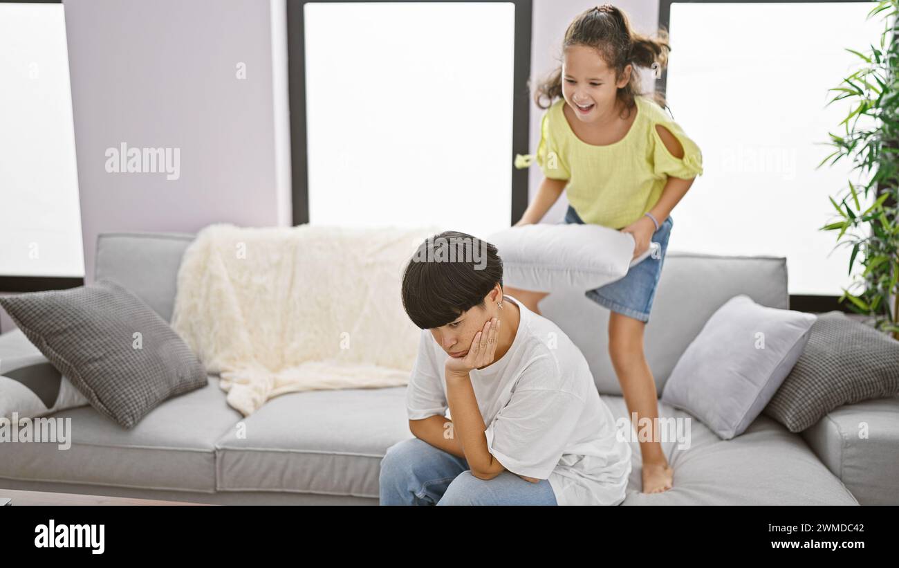 Mother and daughter jumping on sofa, disturbing home's relaxed ...