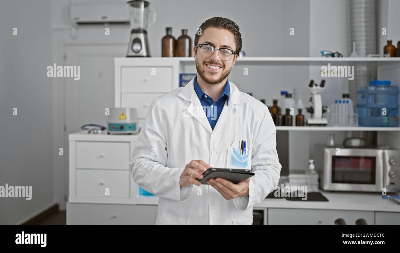 Young hispanic man scientist using touchpad smiling at laboratory Stock Photo - Alamy
