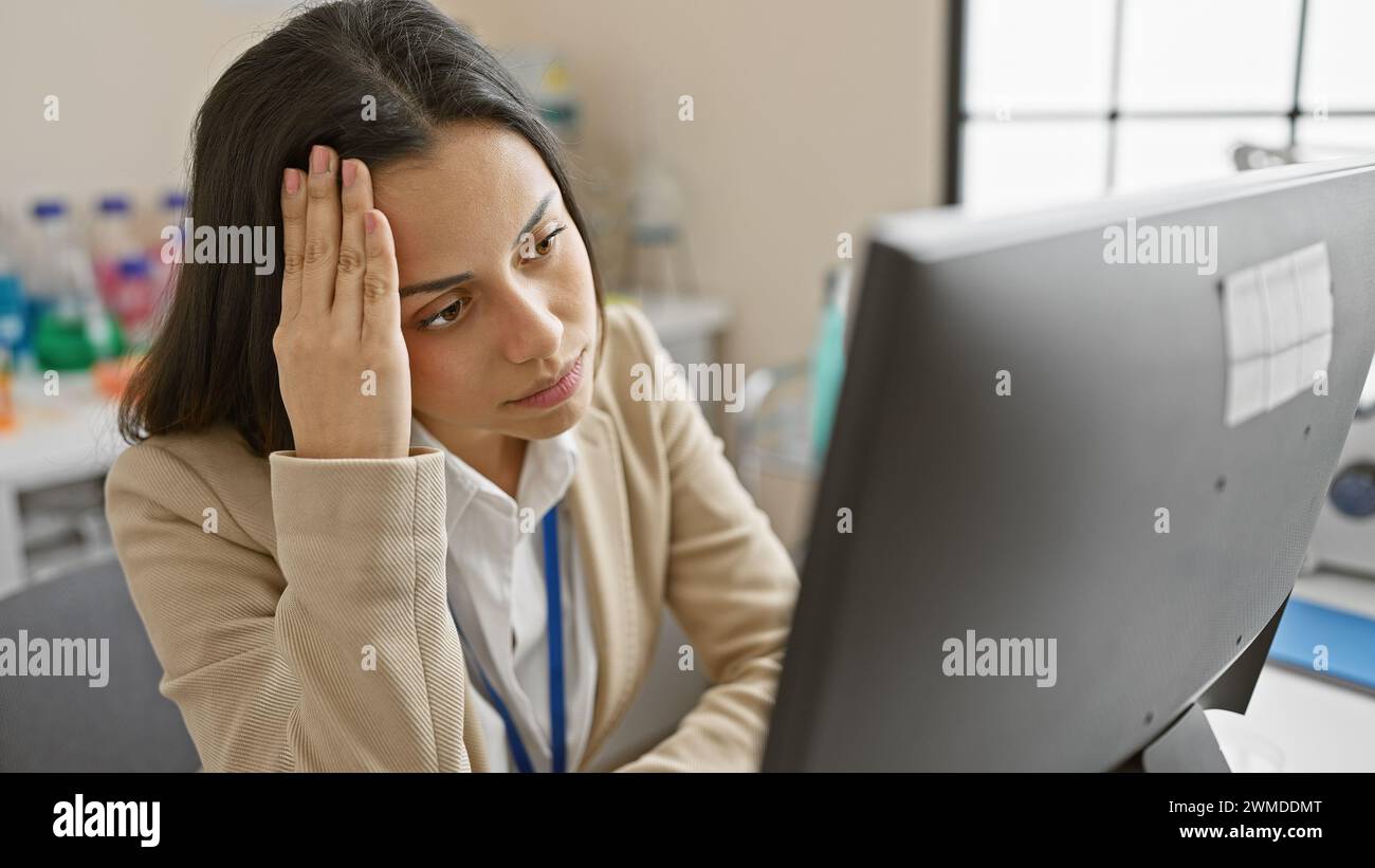 Stressed woman experiencing headache at workplace with computer in ...