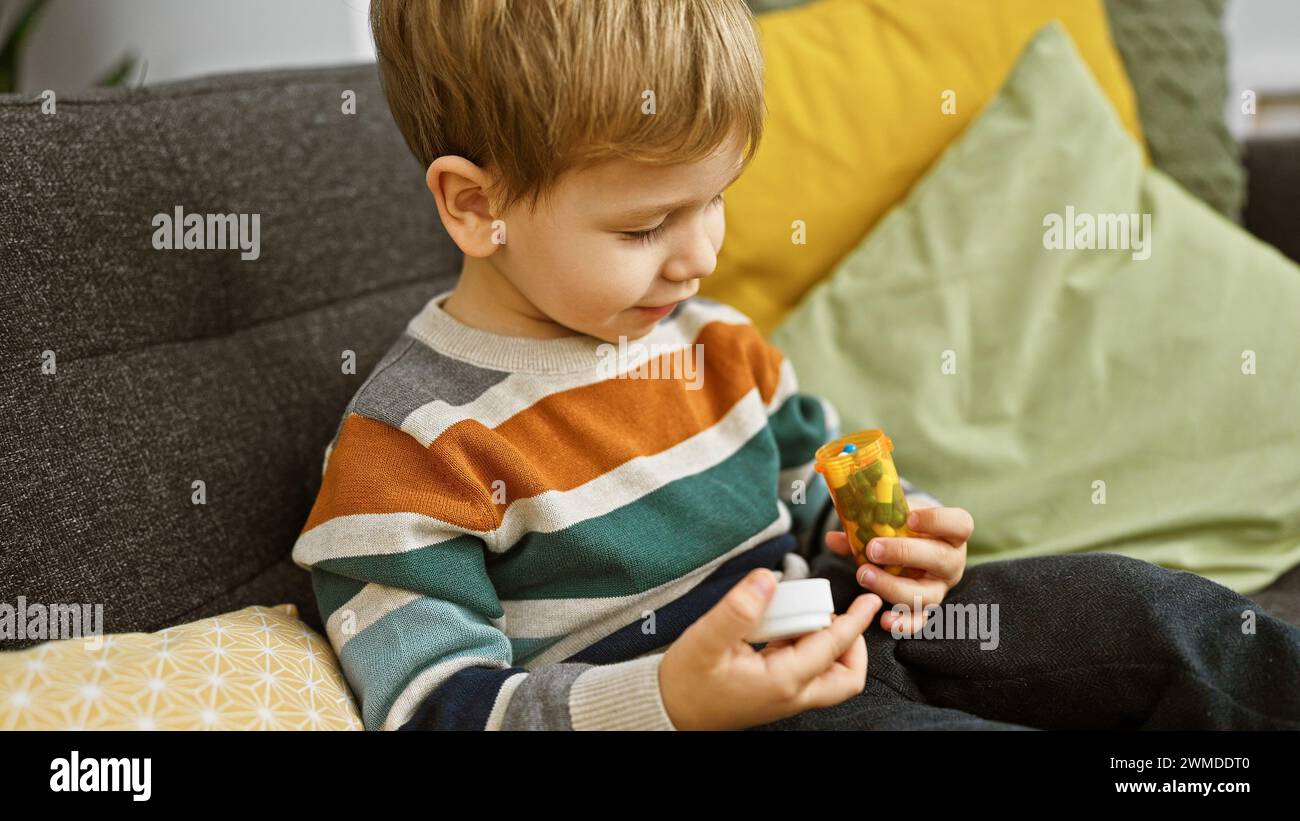 Toddler boy examining a pill bottle at home, depicting potential hazard ...