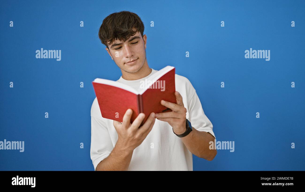 Cool young hispanic teenager absorbed in reading a book, concentrating ...