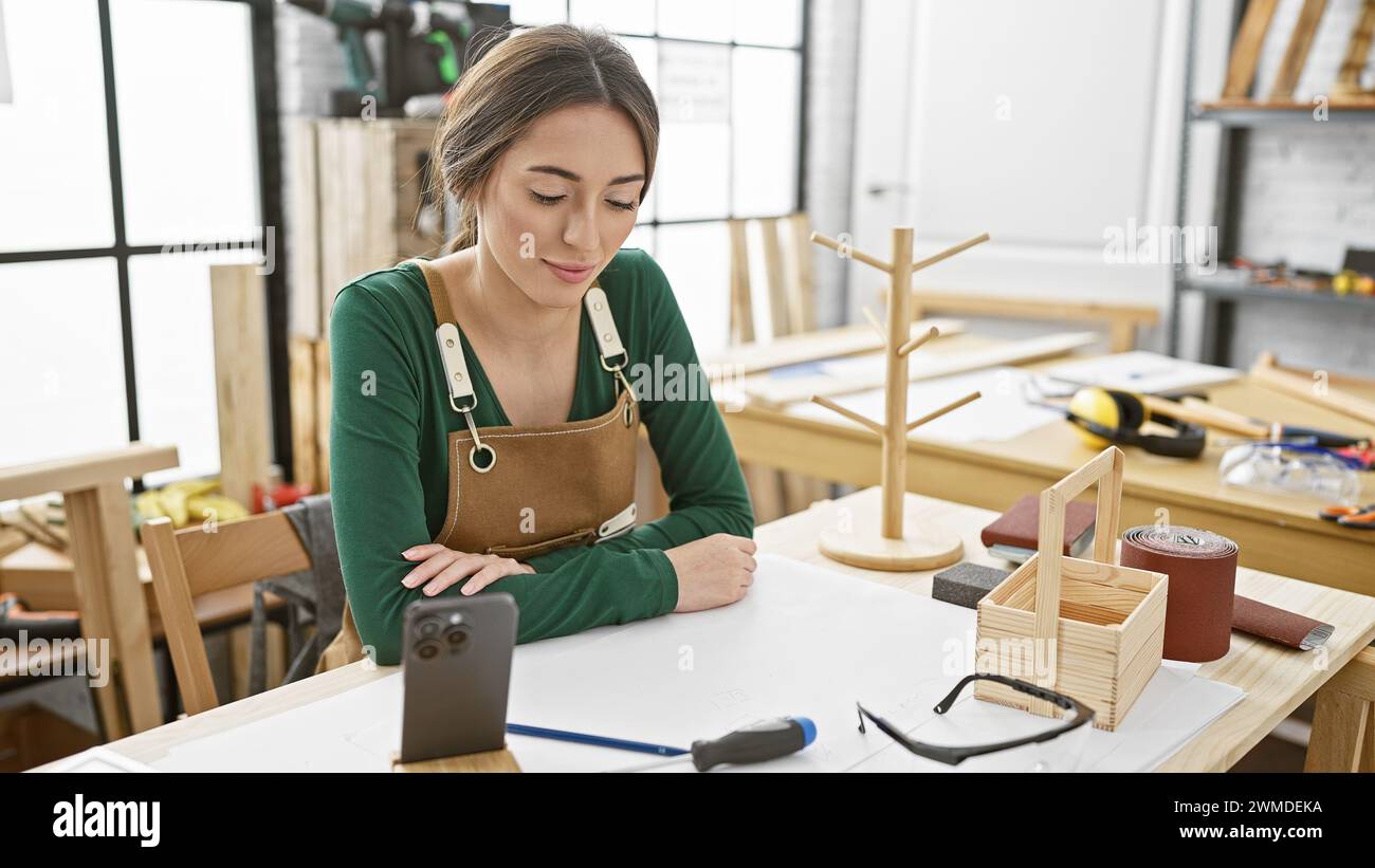 A woman sketches in a carpentry workshop surrounded by wooden furniture ...