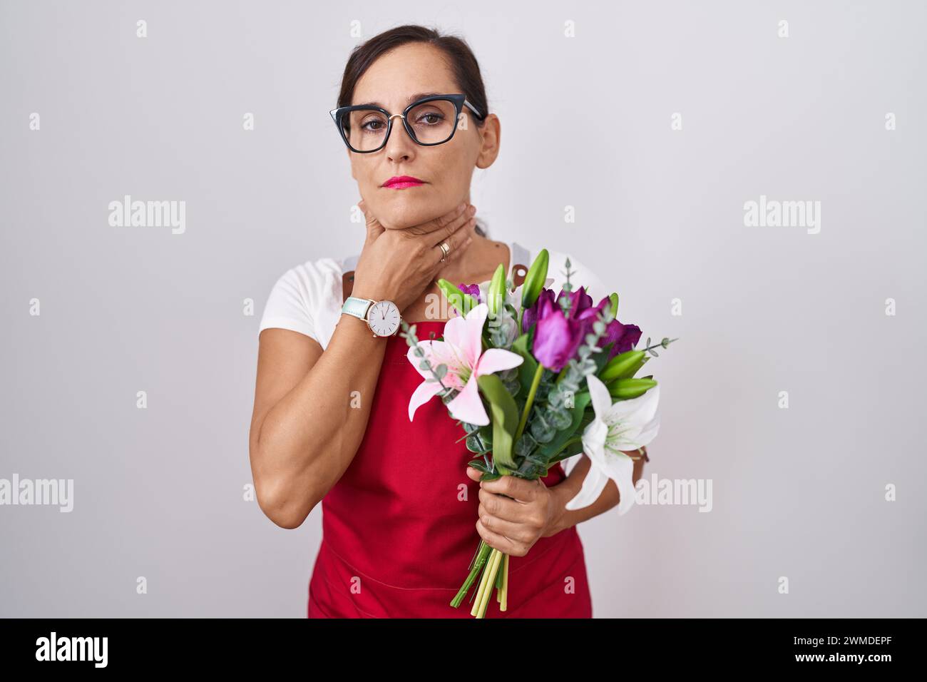 Middle age brunette woman wearing apron working at florist shop holding ...